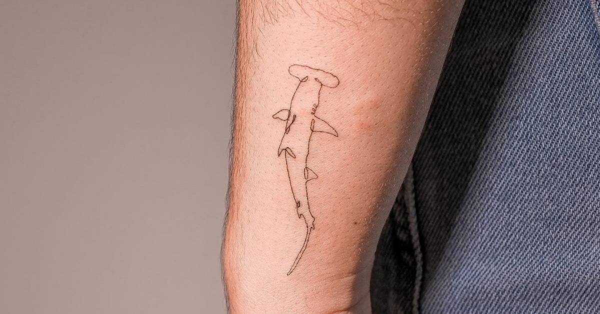 One line hammerhead shark tattoo located on the wrist.