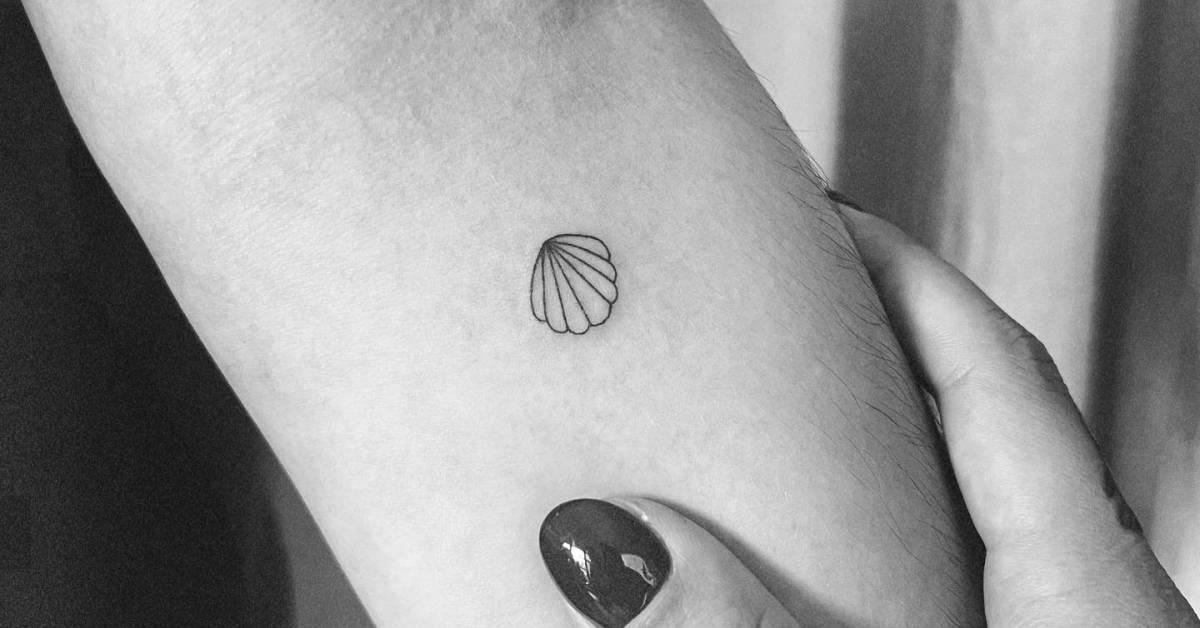 Minimalistic style scallop shell tattoo placed on the