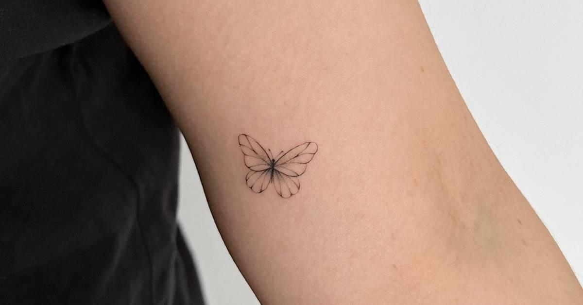 Fine line style butterfly tattoo located on the inner
