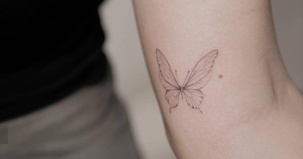 Fine line style butterfly tattoo placed on the inner