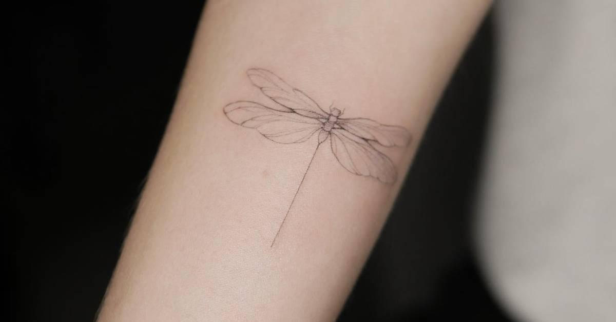 Dragonfly tattoo placed on the inner forearm, fine line
