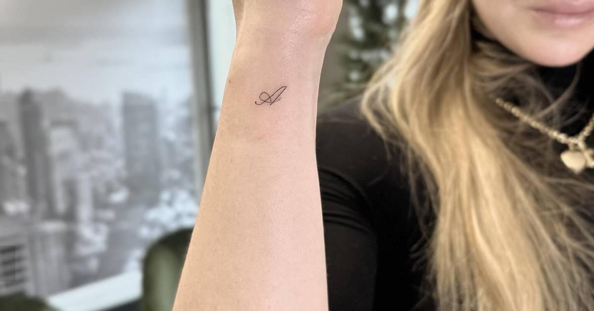 Tiny letter "A" tattoo located on the wrist.