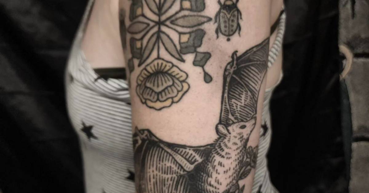 Healed engraving style bat tattoo located on the upper