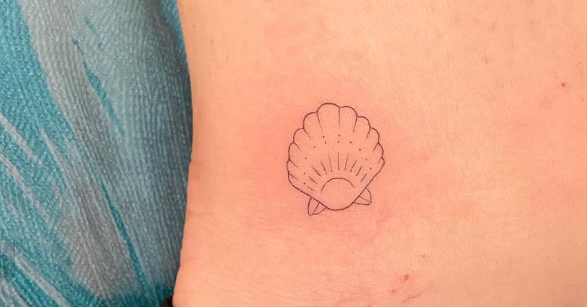 Fine line styke scallop shell tattoo located on the