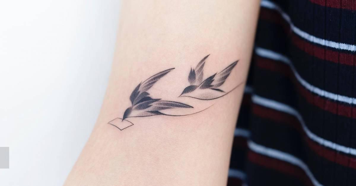 Swallows tattoo done on the bicep, watercolor style.