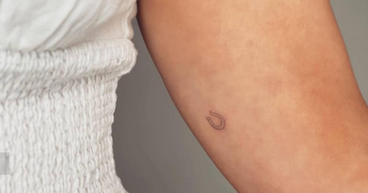 Fine line style horseshoe tattoo located on the inner