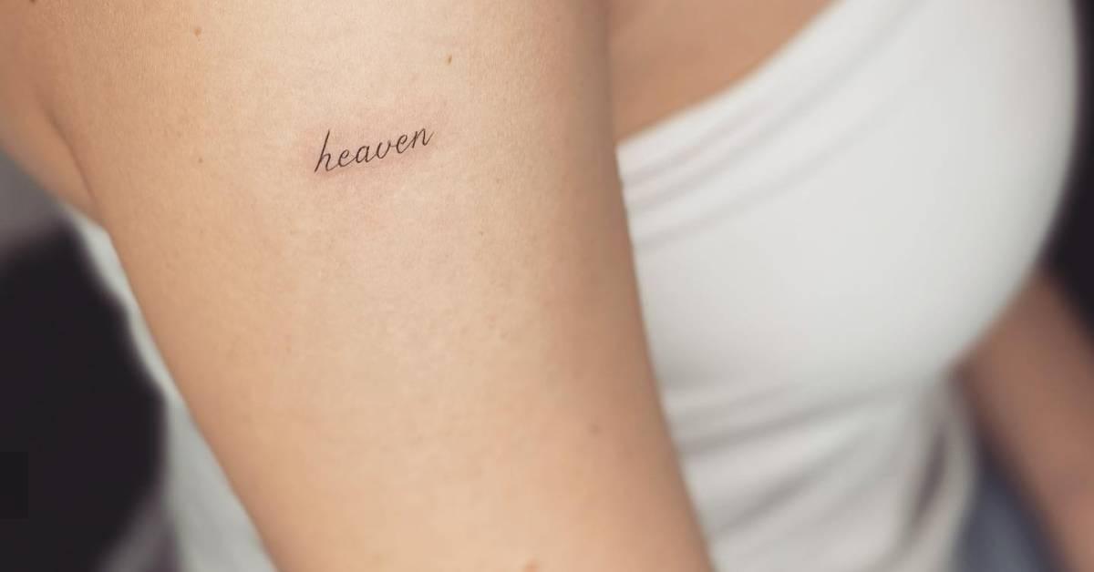 "Heaven" lettering tattoo located on the upper arm.