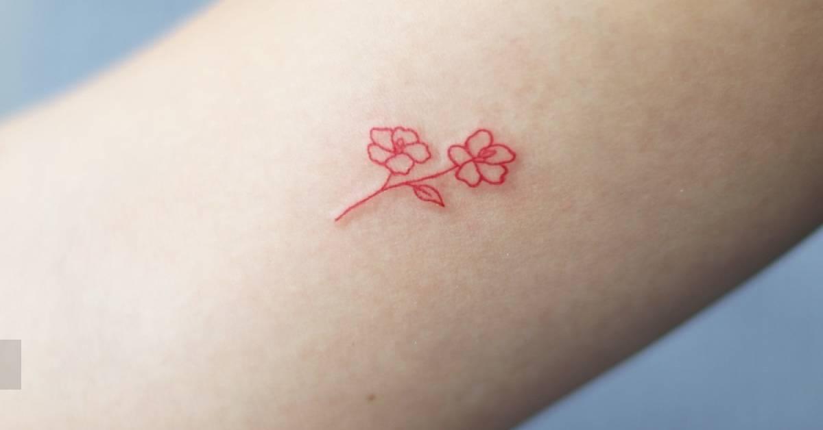Minimalistic style red flowers tattoo done on the inner