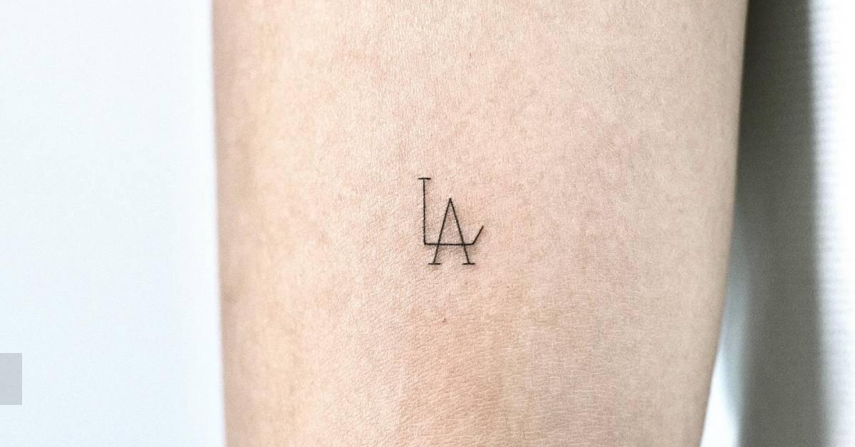 "LA" lettering tattoo located on the upper arm.