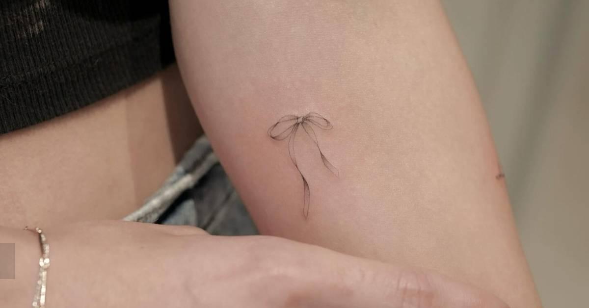 Illustrative style ribbon tattoo done on the inner