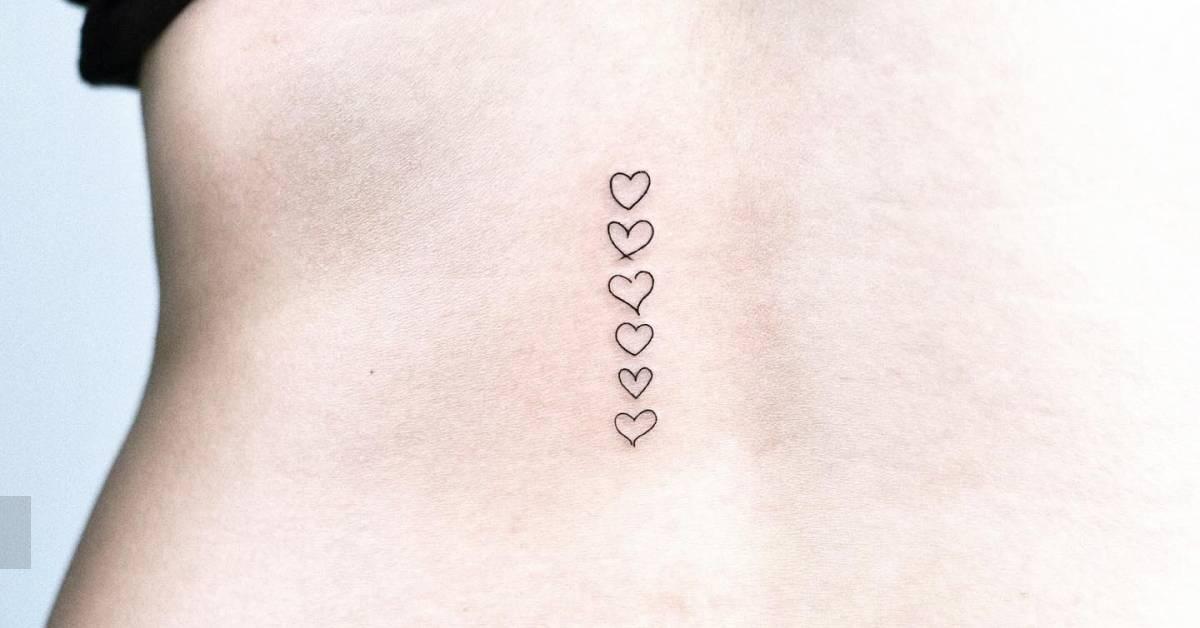 Minimalistic style hearts tattooed on the lower back.