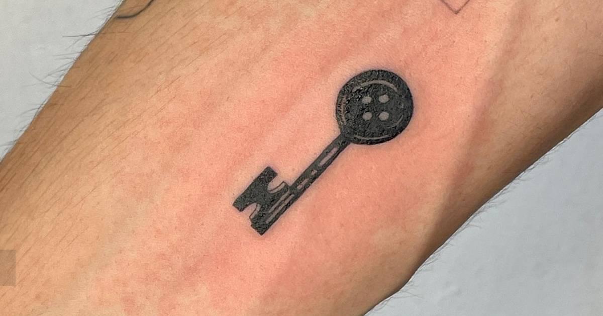 Button key tattoo located on the inner forearm,