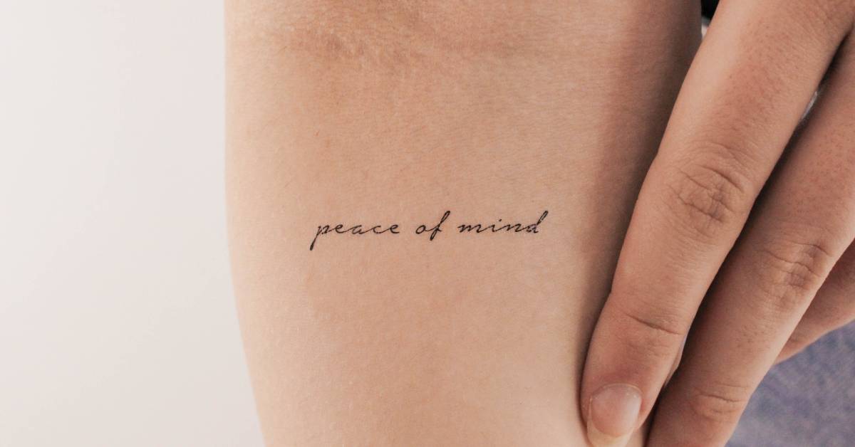 "Peace of mind" temporary lettering tattoo located on