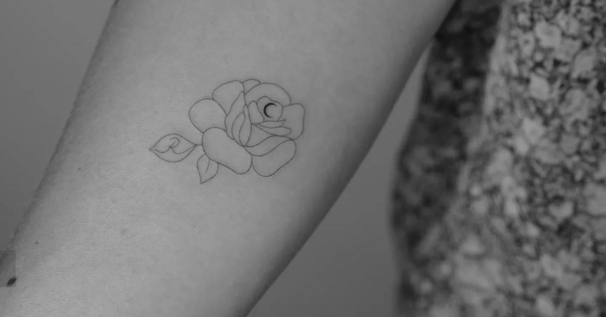 Fine line style rose head tattoo located on the inner