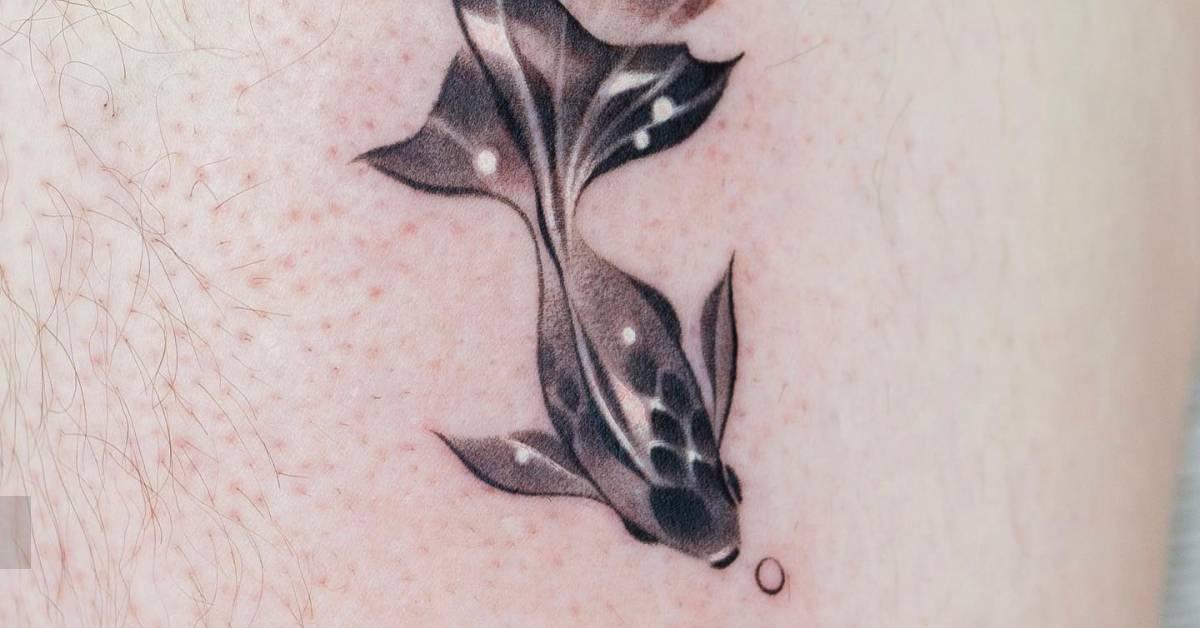 Watercolor style fish tattoo placed on the upper arm.