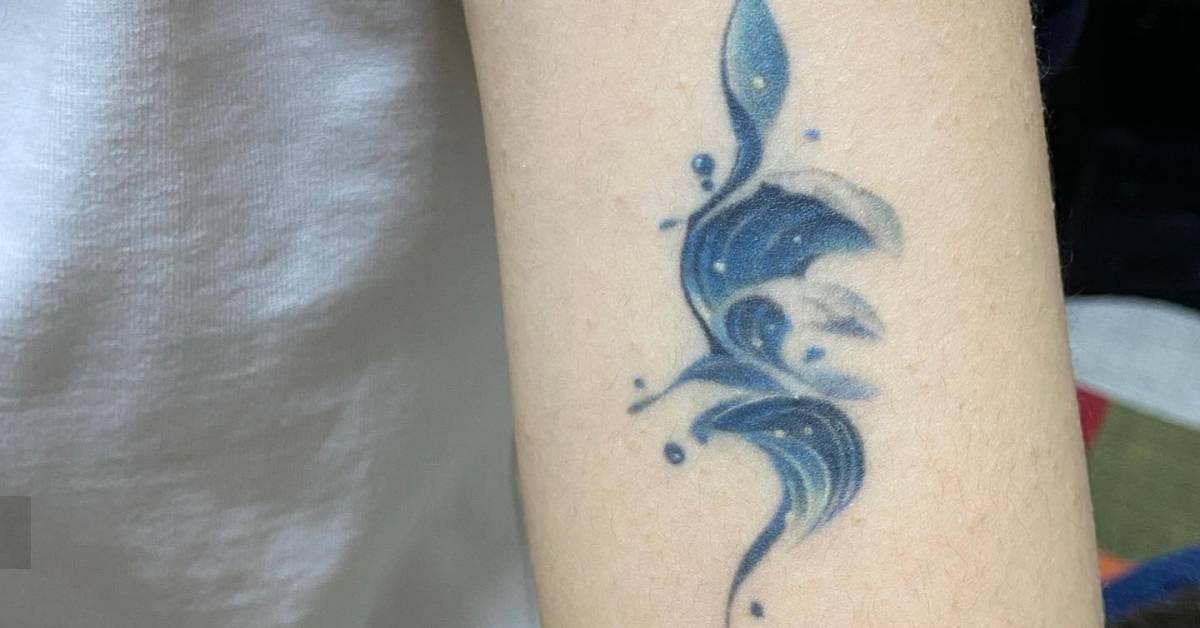 Abstract wave tattoo located on the upper arm,