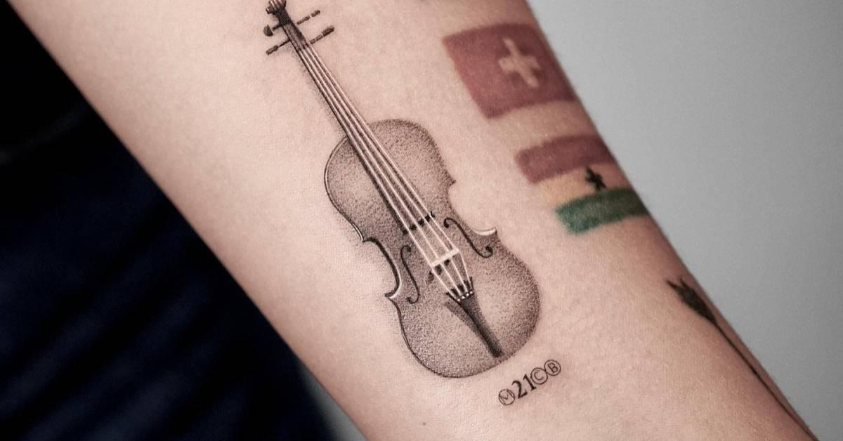 Micro-realistic style violin tattoo placed on the inner