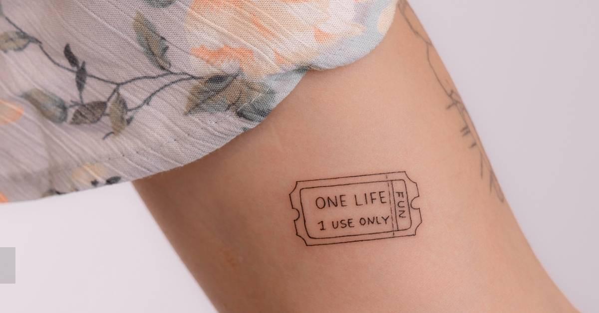 Admission ticket tattoo located on the inner arm.