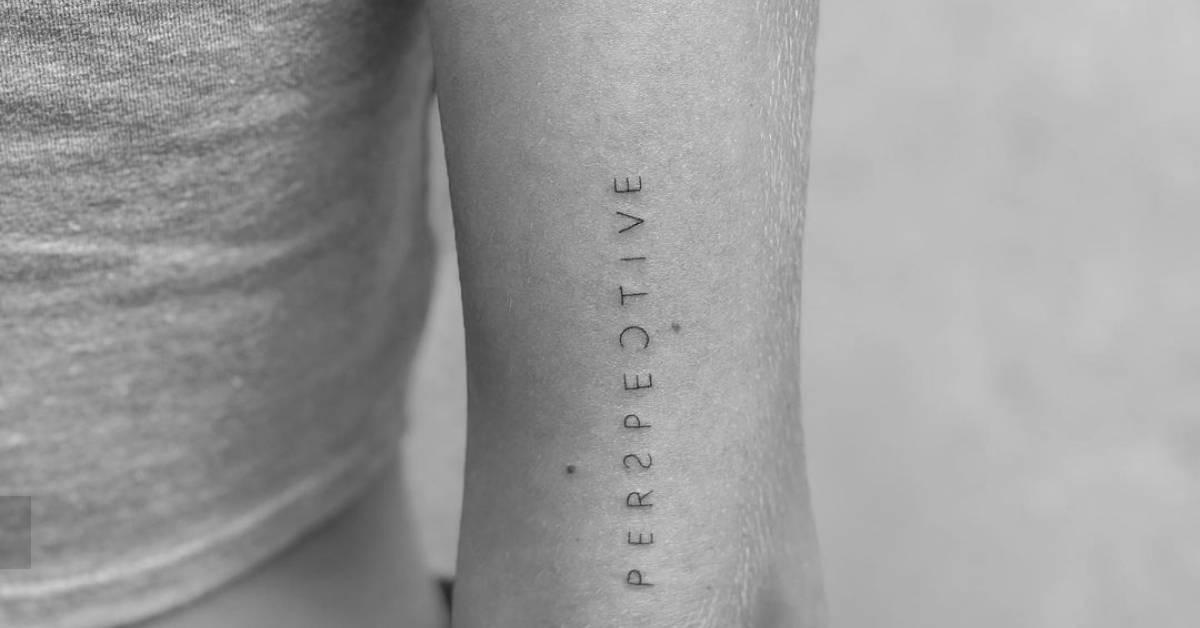"Perspective" lettering tattoo on the tricep.