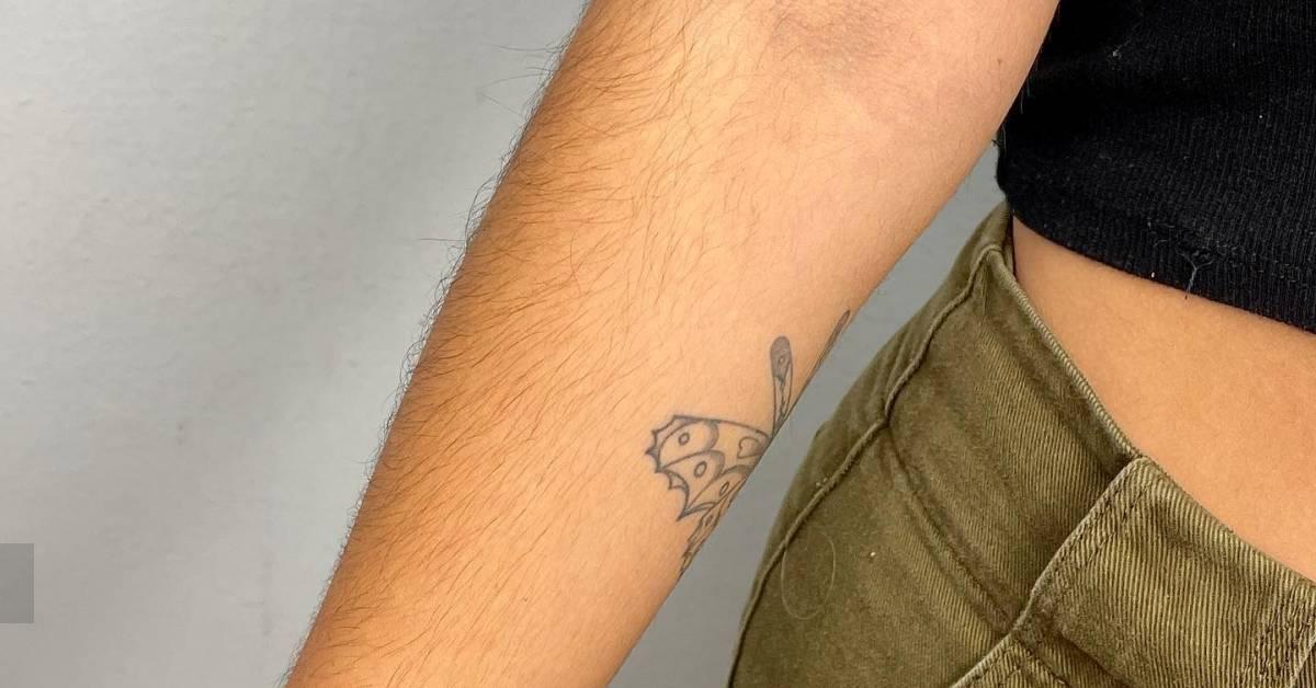 Number "222" and ribbon tattoos located on the wrist