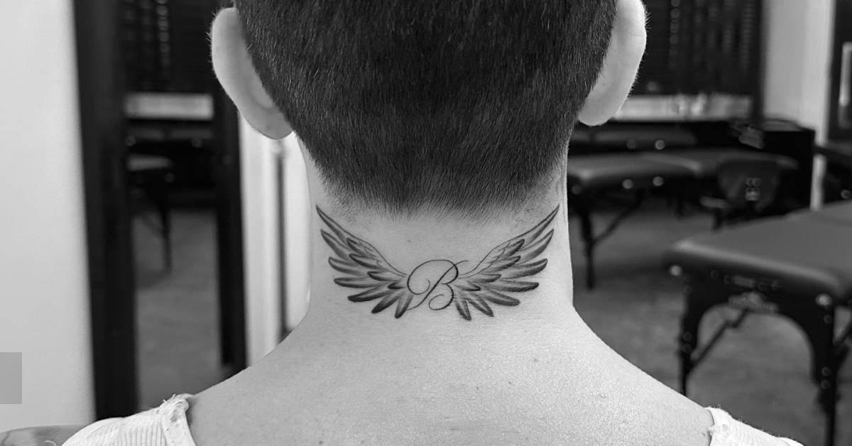 Wings and letter "B" tattoo located on the back of the
