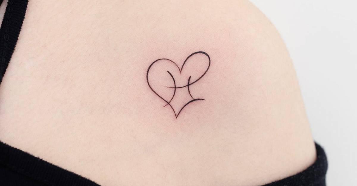 Pisces zodiac symbol and heart tattooed on the