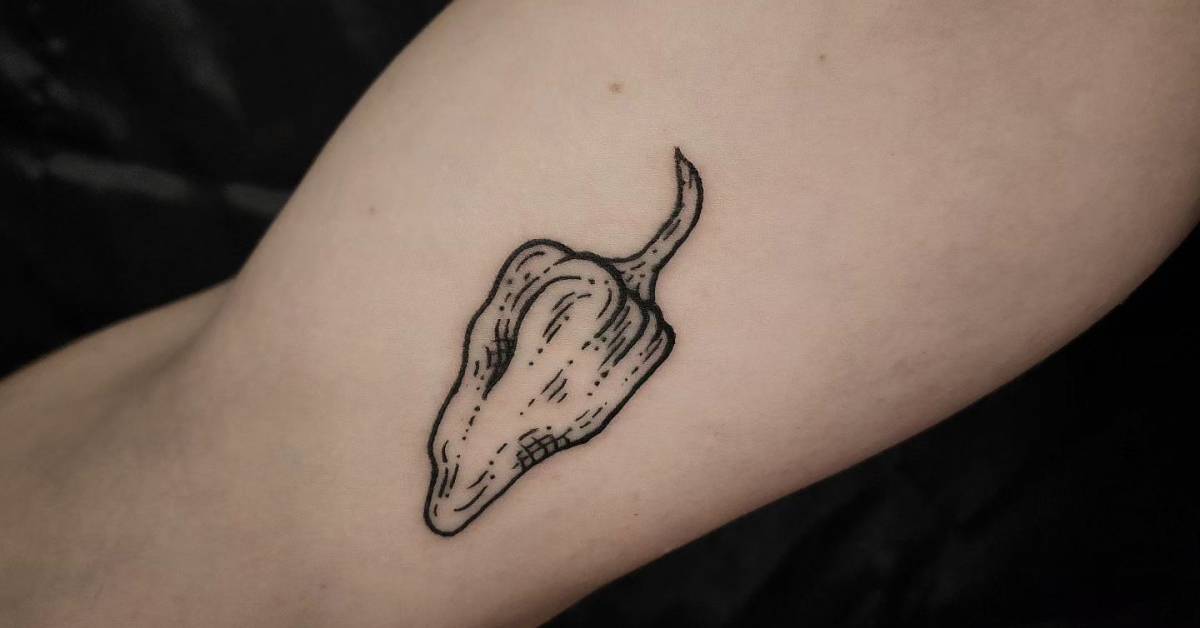 Chili pepper tattoo located on the inner arm, done in