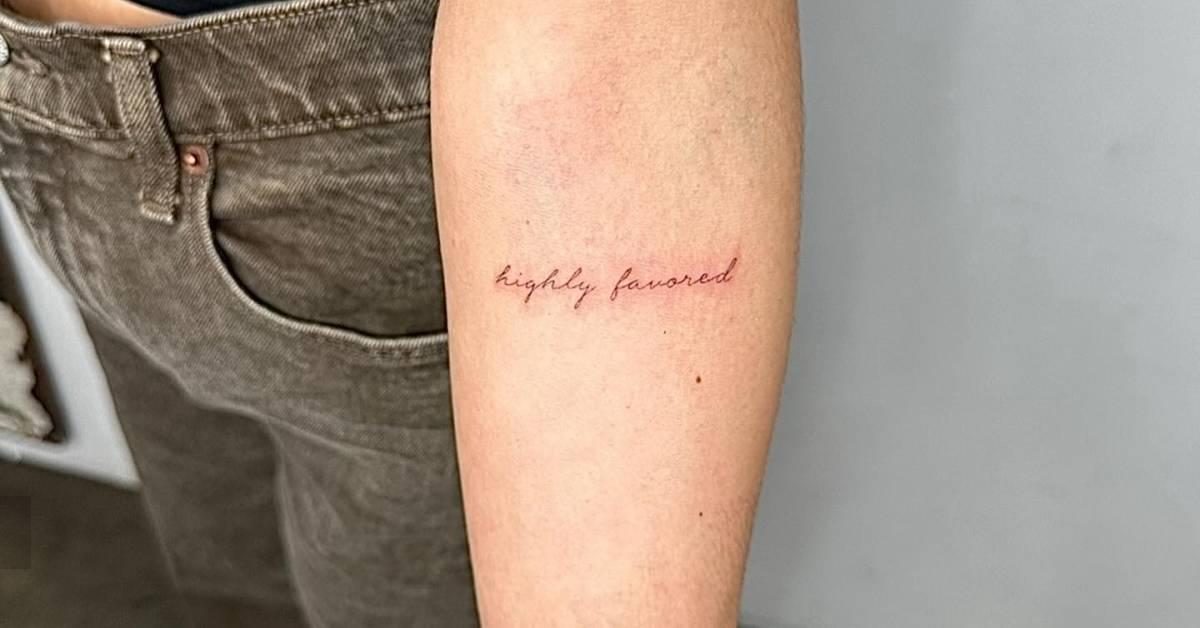 "Highly favored" lettering tattoo handwritten on the