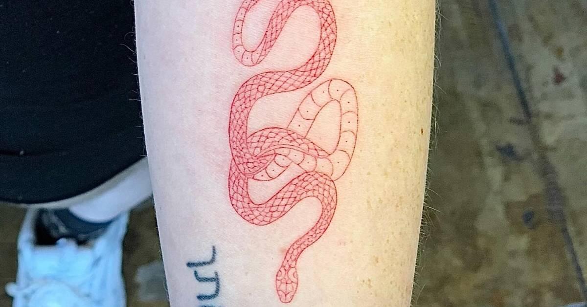 Fine line red snake tattoo located on the inner
