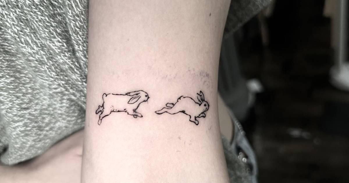 Fine line bunnies tattoo located on the bicep.