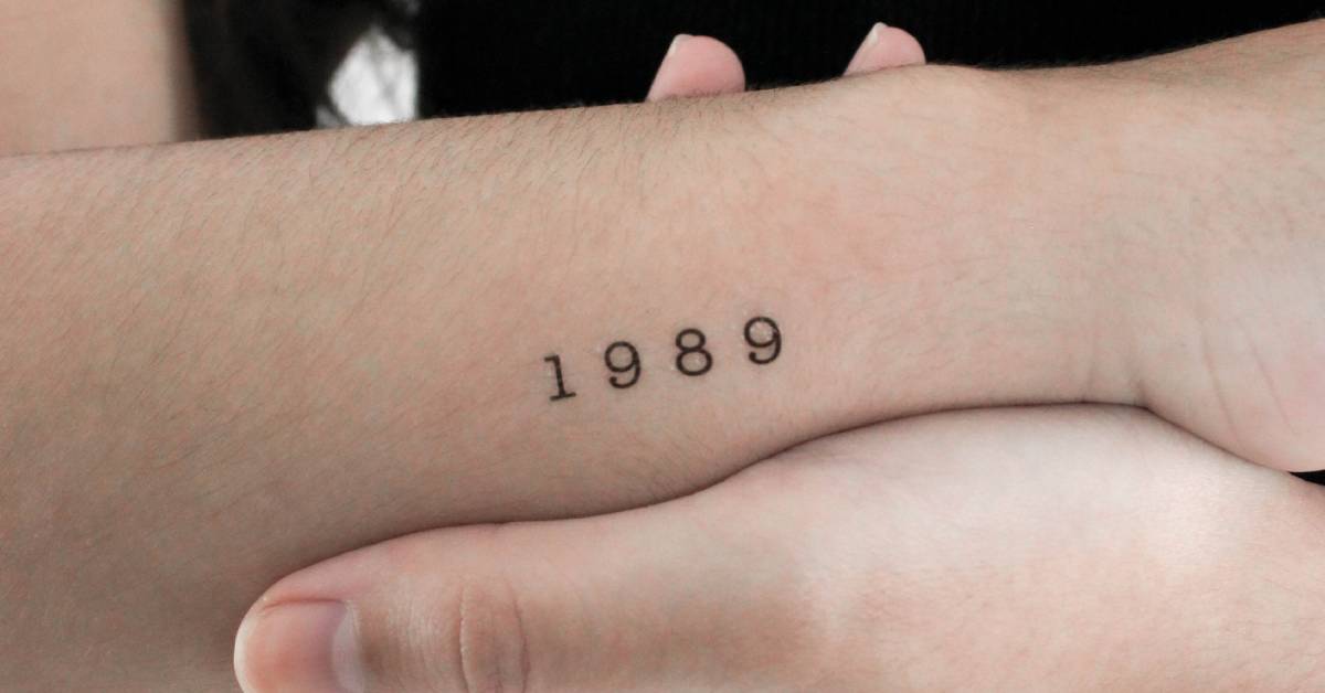 "1989" temporary lettering tattoo located on the wrist.