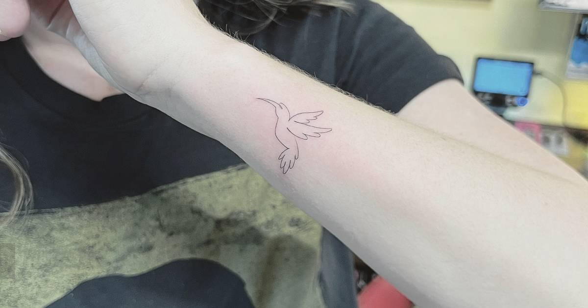 One line hummingbird tattoo placed on the wrist.