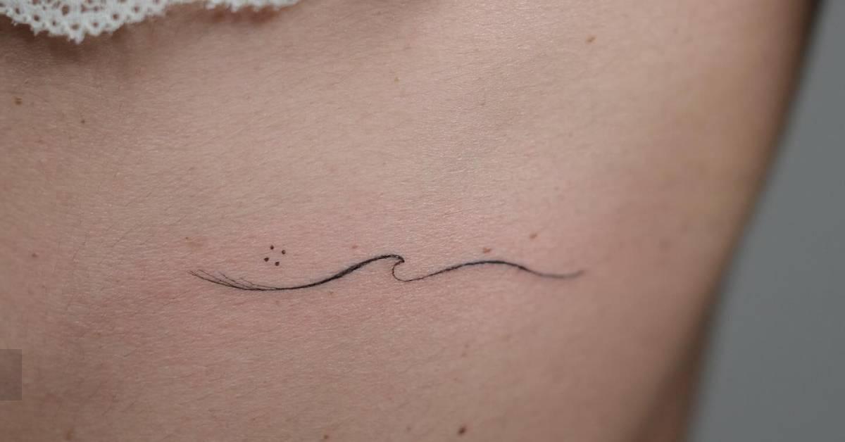 Minimalistic style wave tattoo placed on the rib.