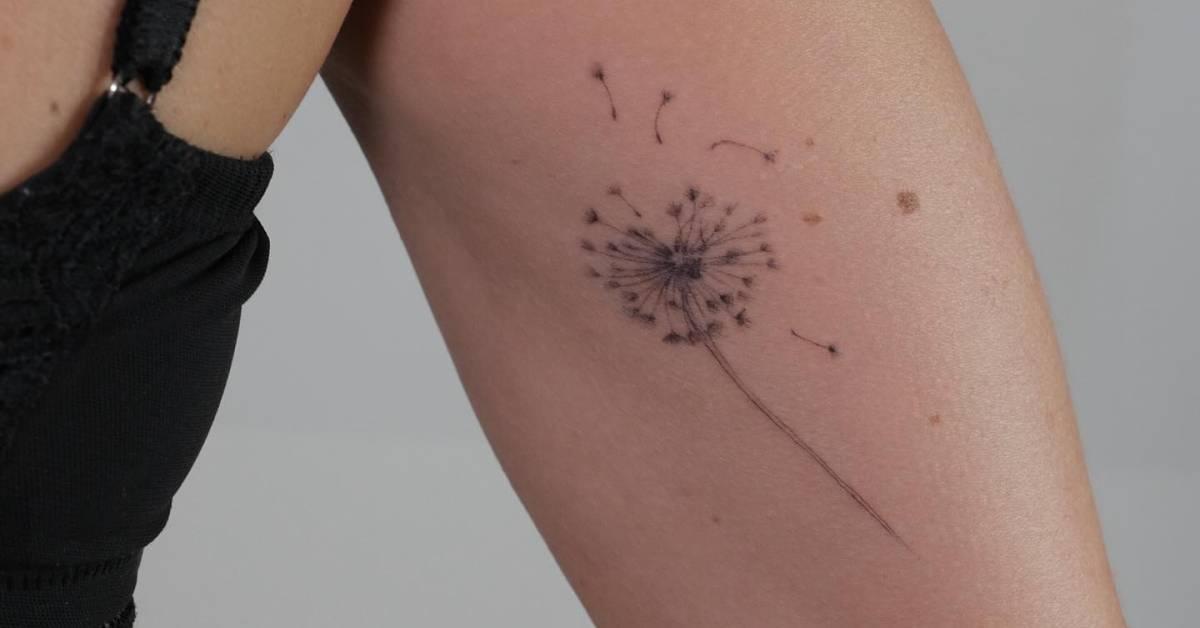 Micro-realistic style dandelion tattoo located on the