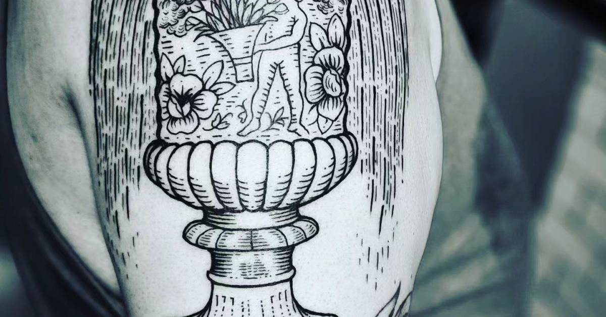 Engraving style vase tattoo placed on the upper arm.