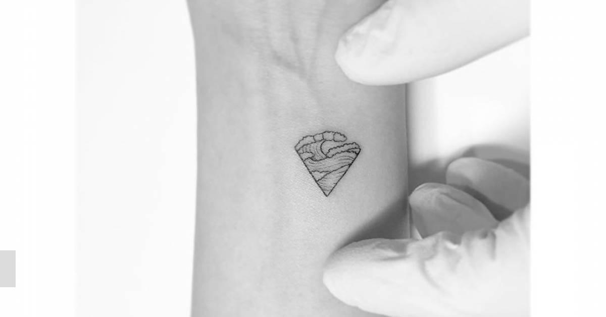 Tiny minimalistic wave tattoo placed on the wrist.