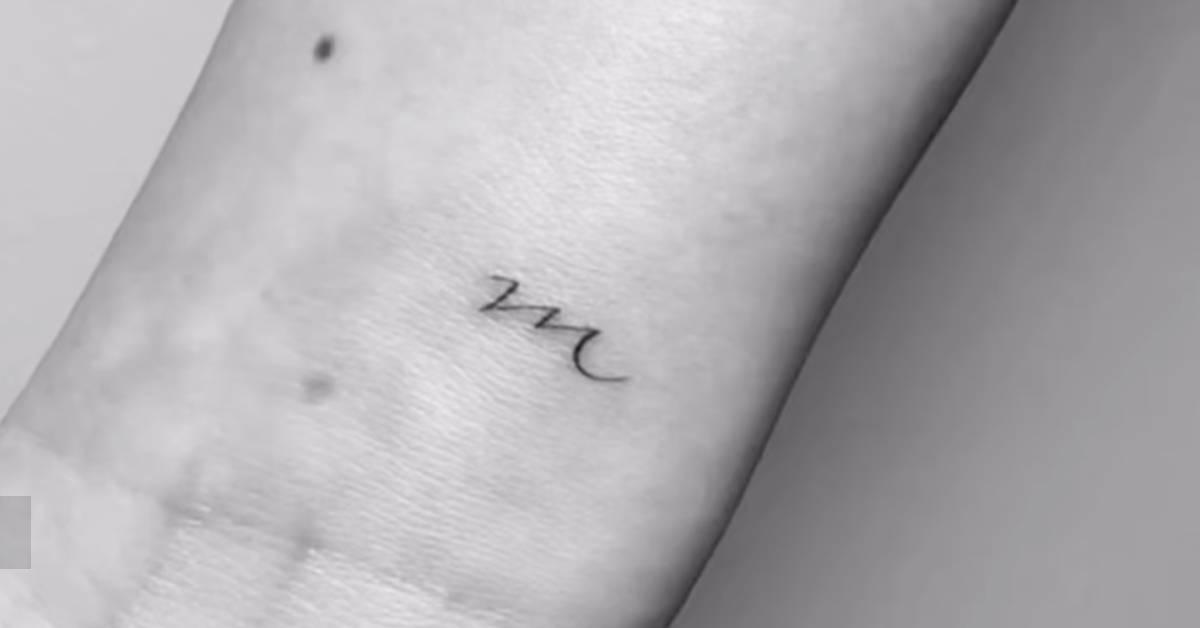 Minimalistic letter "M" tattoo placed on Camilla