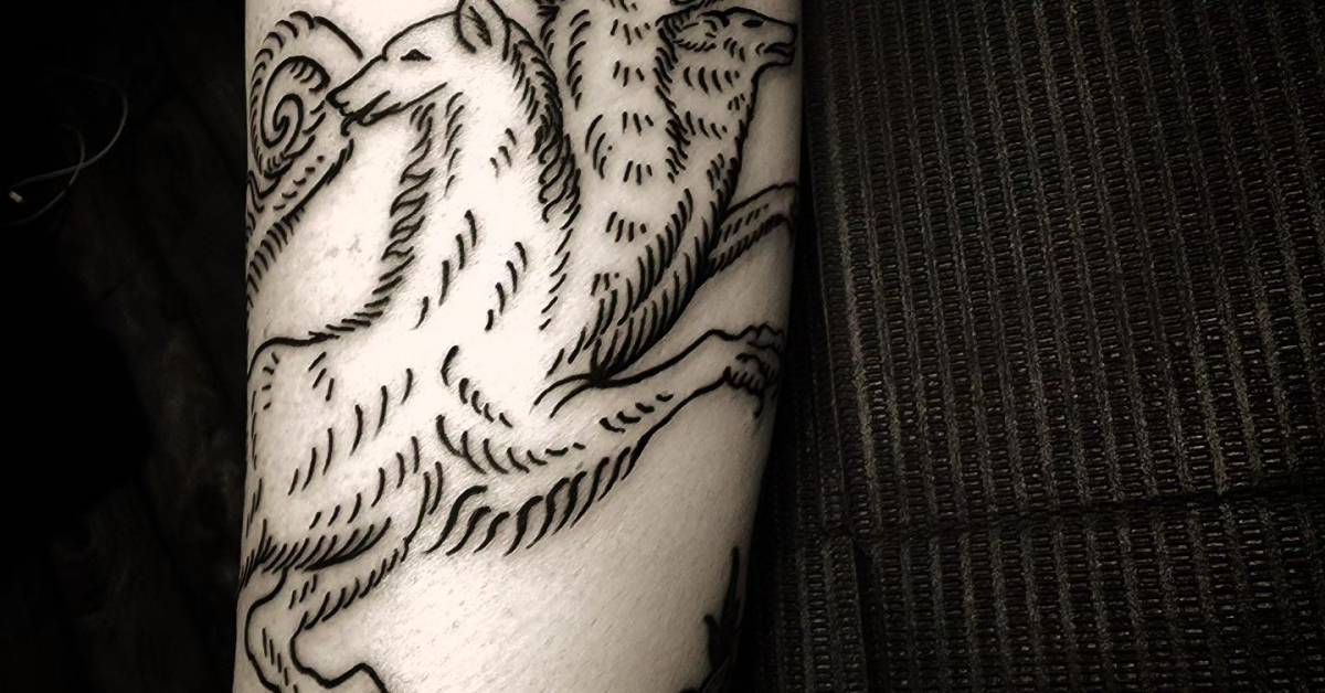 Engraving style Cerberus tattoo located on the forearm.