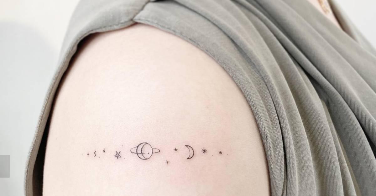 Minimalistic universe tattoo located on the upper arm.