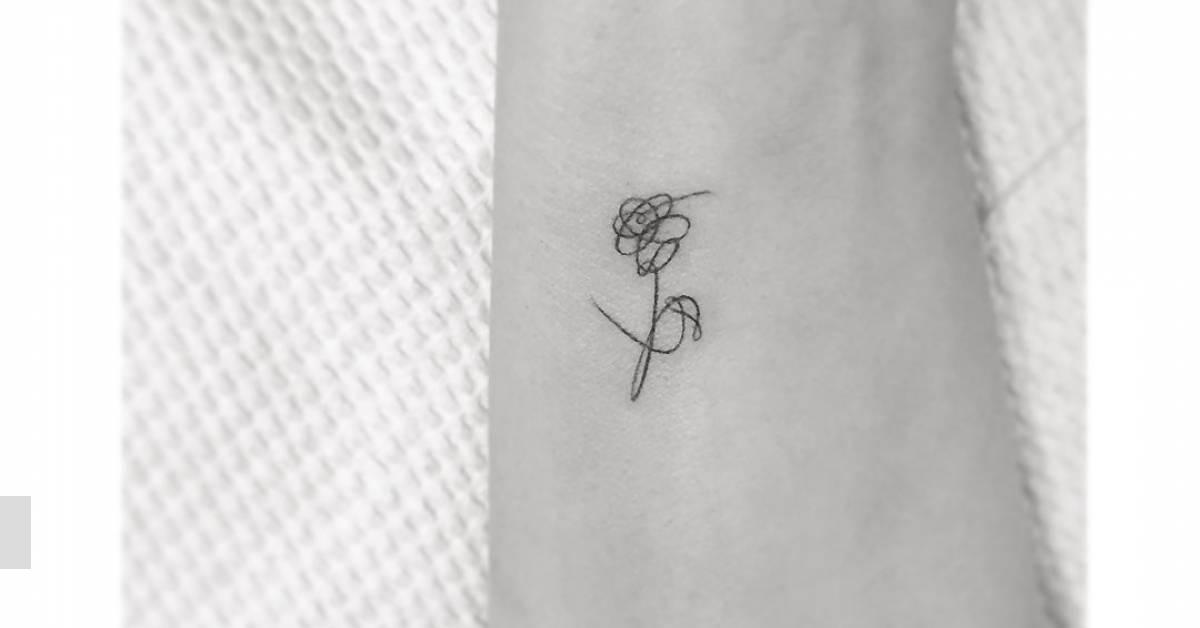 One line flower tattoo located on the wrist.