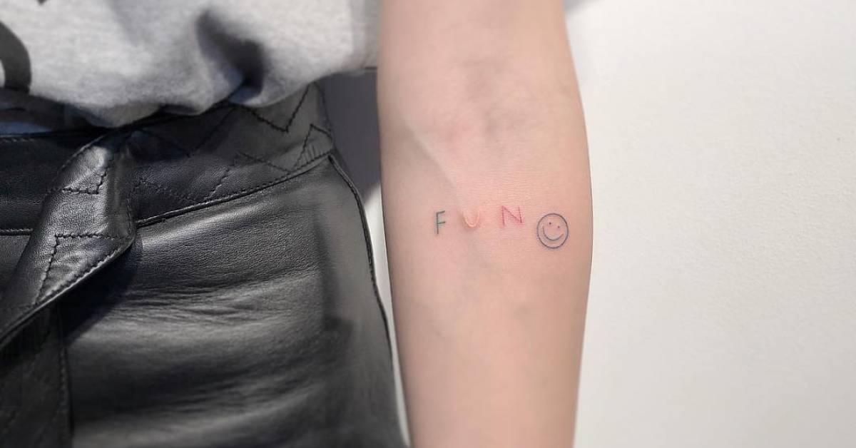 Tattoo of the word "fun" and smiley face located on the