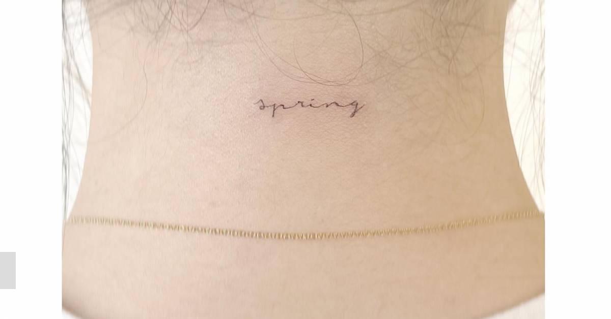 Tattoo of the word "spring" handwritten on the back of
