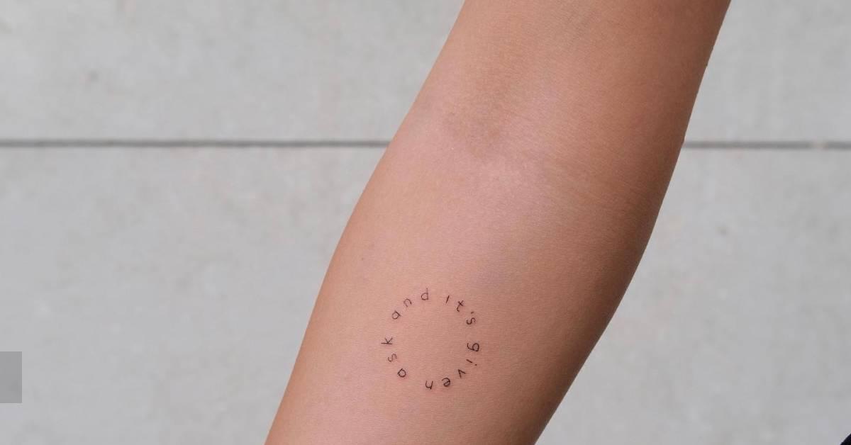 "Ask and it's given" lettering tattoo placed on the