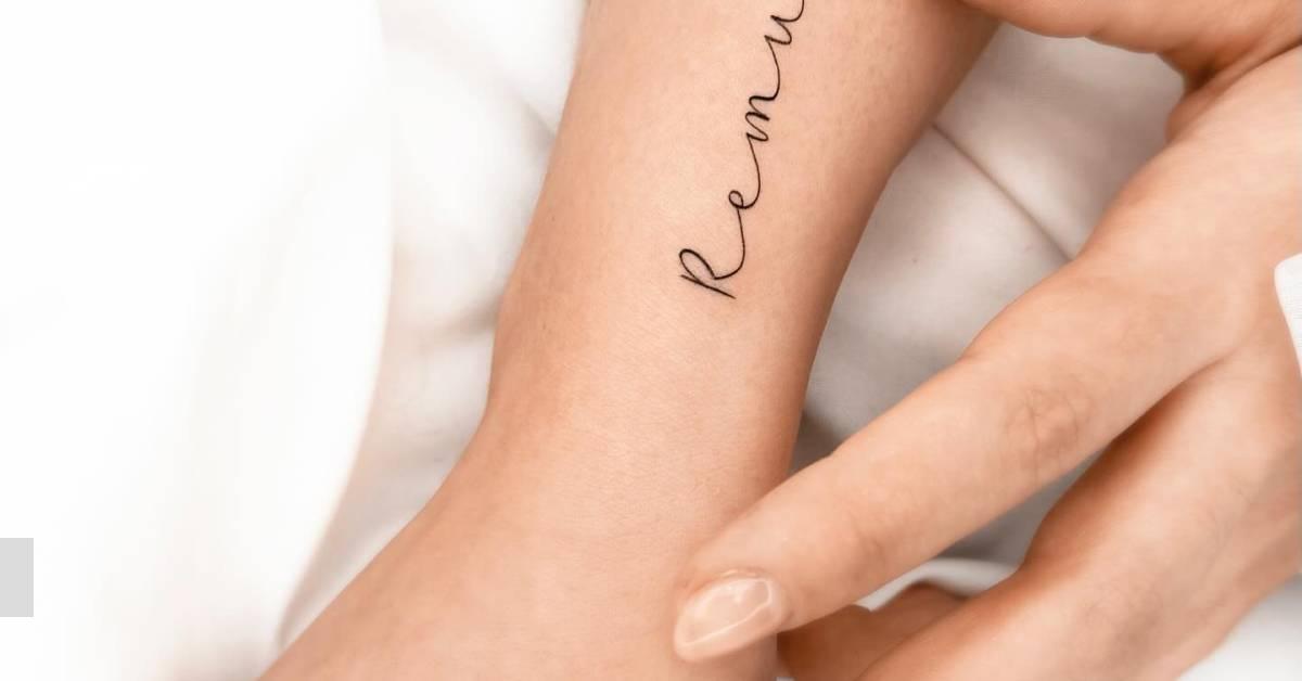 "Remus" lettering tattoo located on the wrist.