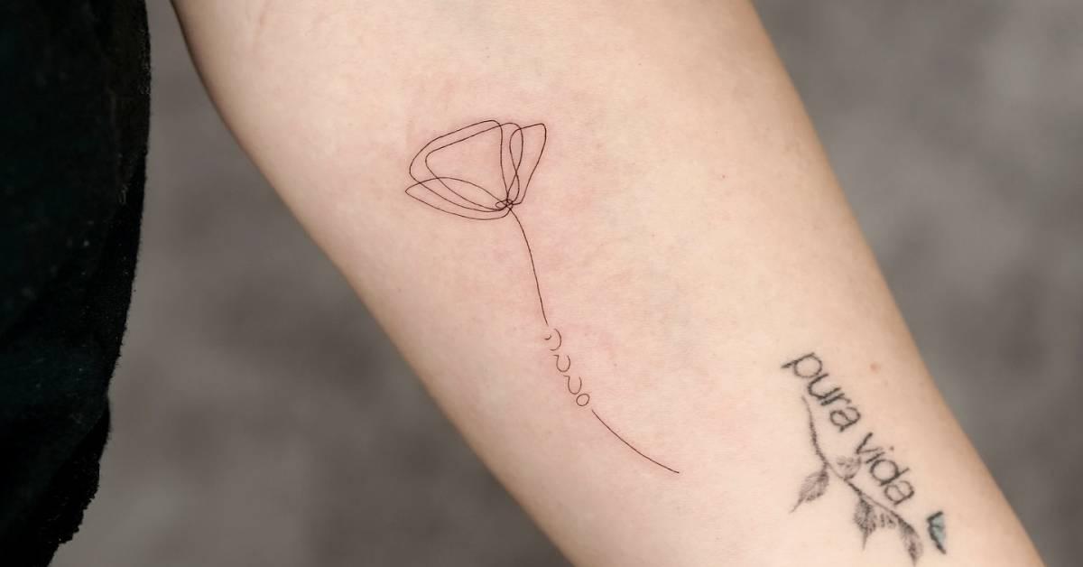 Fine line style poppy flower tattoo located on the