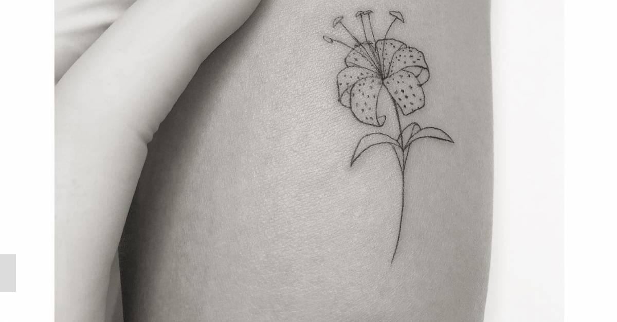 Fine line style lily flower tattoo located on the inner