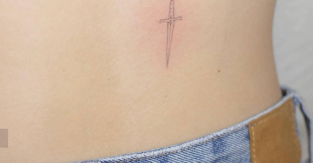 Fine line style dagger tattoo located on the lower