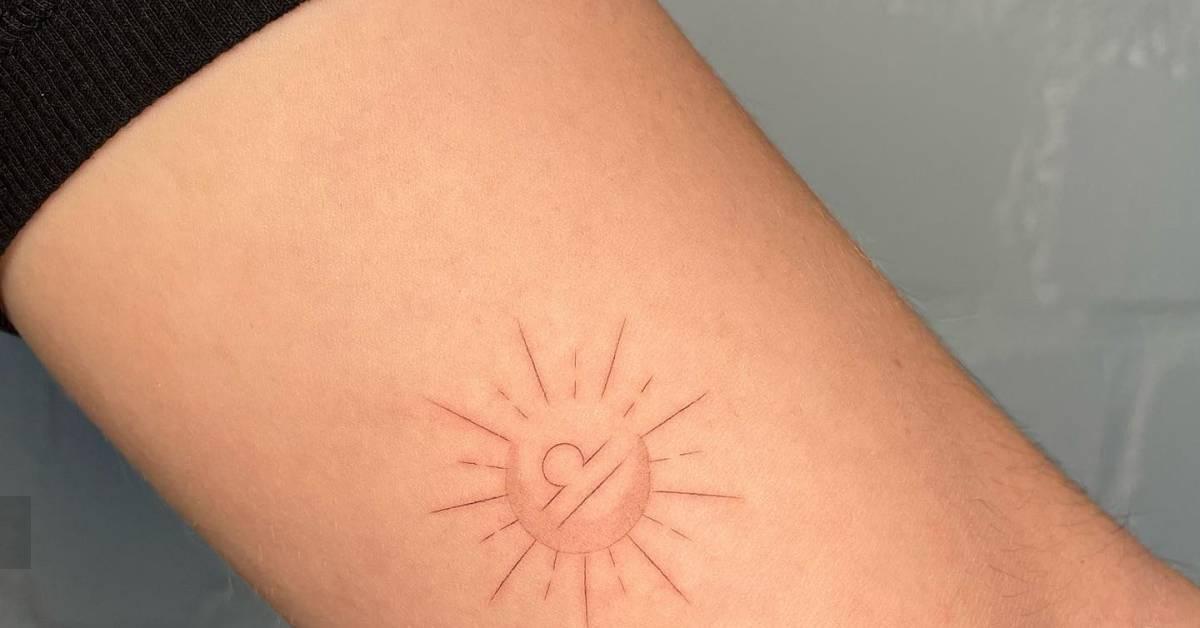Fine line style sun and Libra symbol tattooed on the