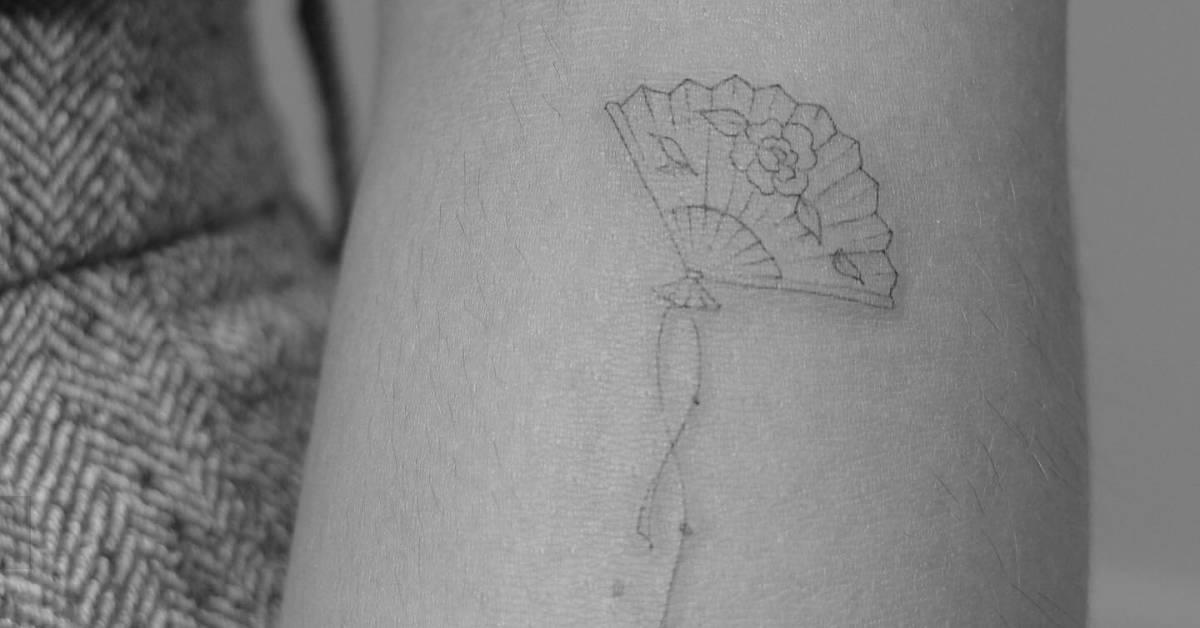 Hand fan tattoo in fine line style located on the