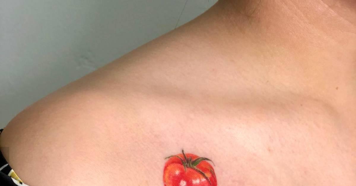 Watercolor style tomato tattoo located on the